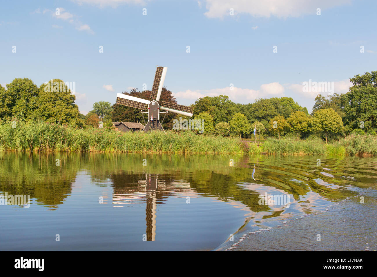 Dutch windmill in landscape with river Stock Photo - Alamy