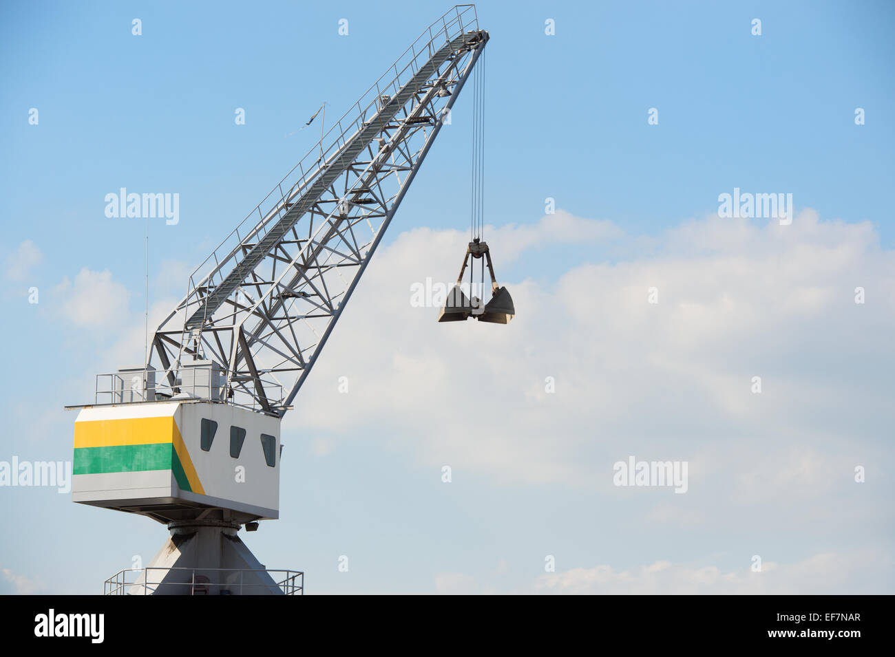 Open industrial crane hanging in blue sky Stock Photo - Alamy