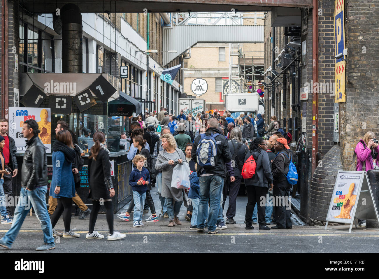 Crowd of people at market stalls and shops in Brick Lane in London, on ...