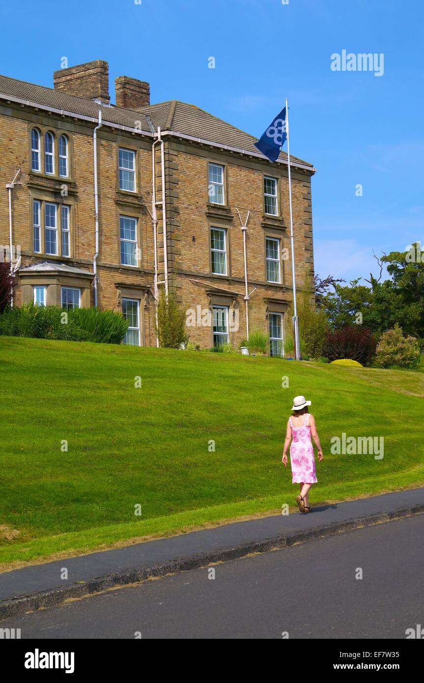 Woman walking below Gilsland Spa Hotel. Gilsland, Cumbria, England, UK ...