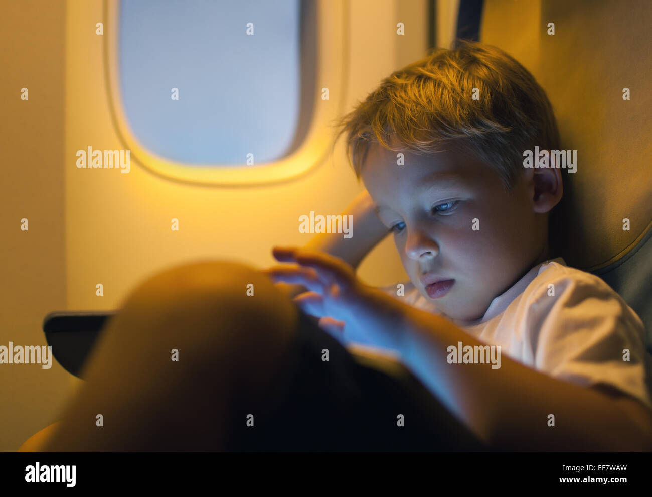 Little boy using tablet computer during flight Stock Photo - Alamy