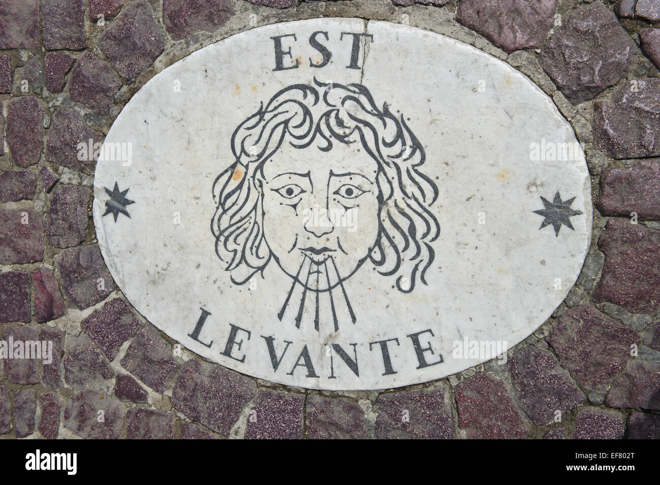 A circular plaque of wind direction embedded in the pavement in St ...