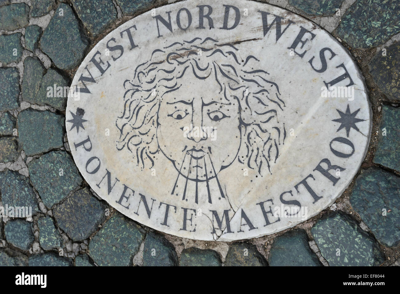 A circular plaque of wind direction embedded in the pavement in St ...