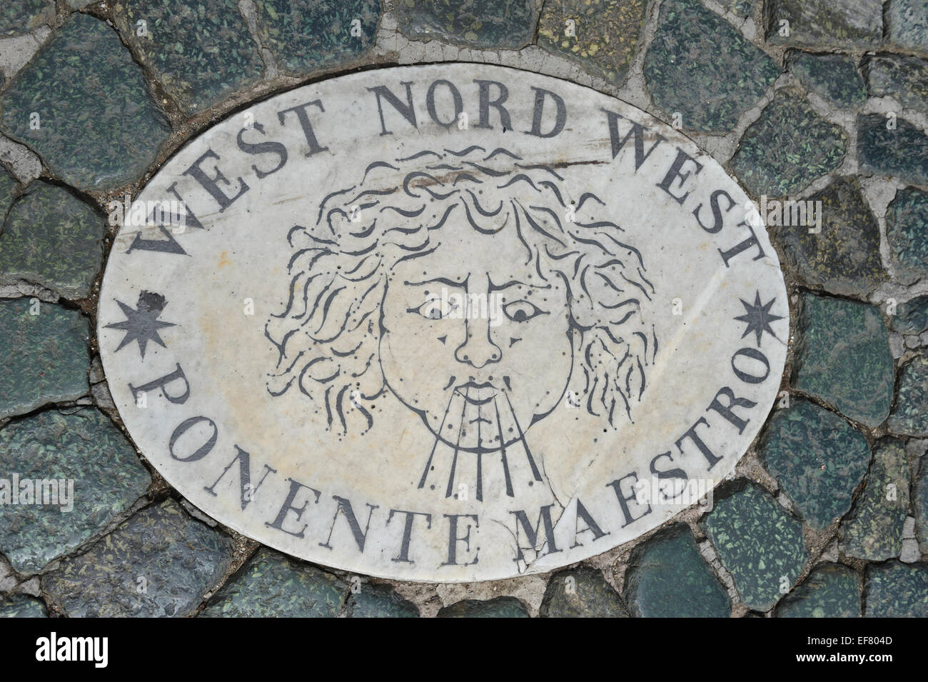 A circular plaque of wind direction embedded in the pavement in St ...