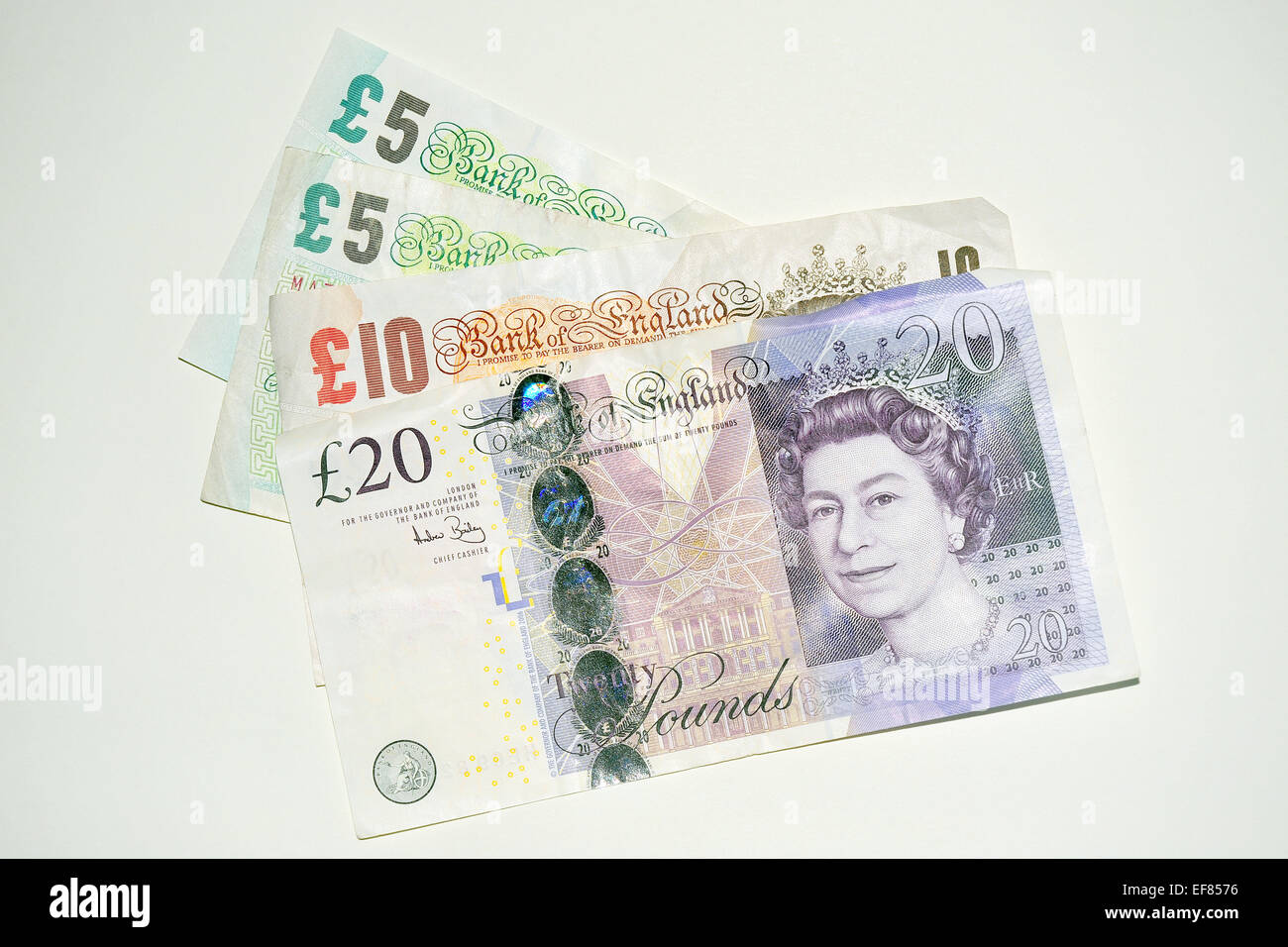 British £5, £10 and £20 currency notes photographed against a white ...