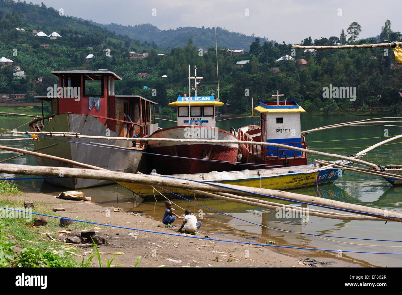 Metal cargo boats and wooden fishing boats on the Rwandan site of Lake ...