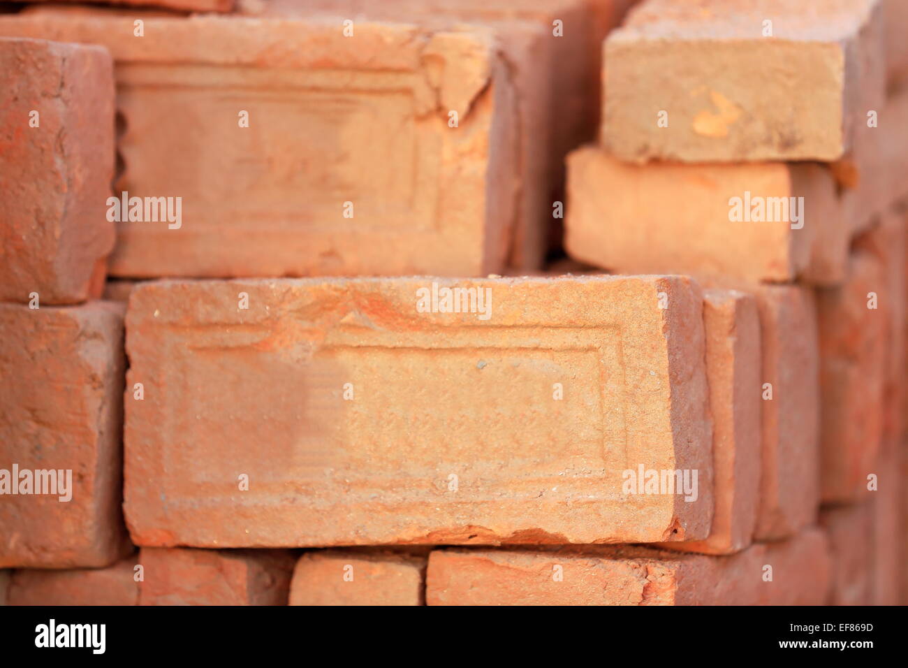 Building materials: red bricks for construction piled on the floor of a ...