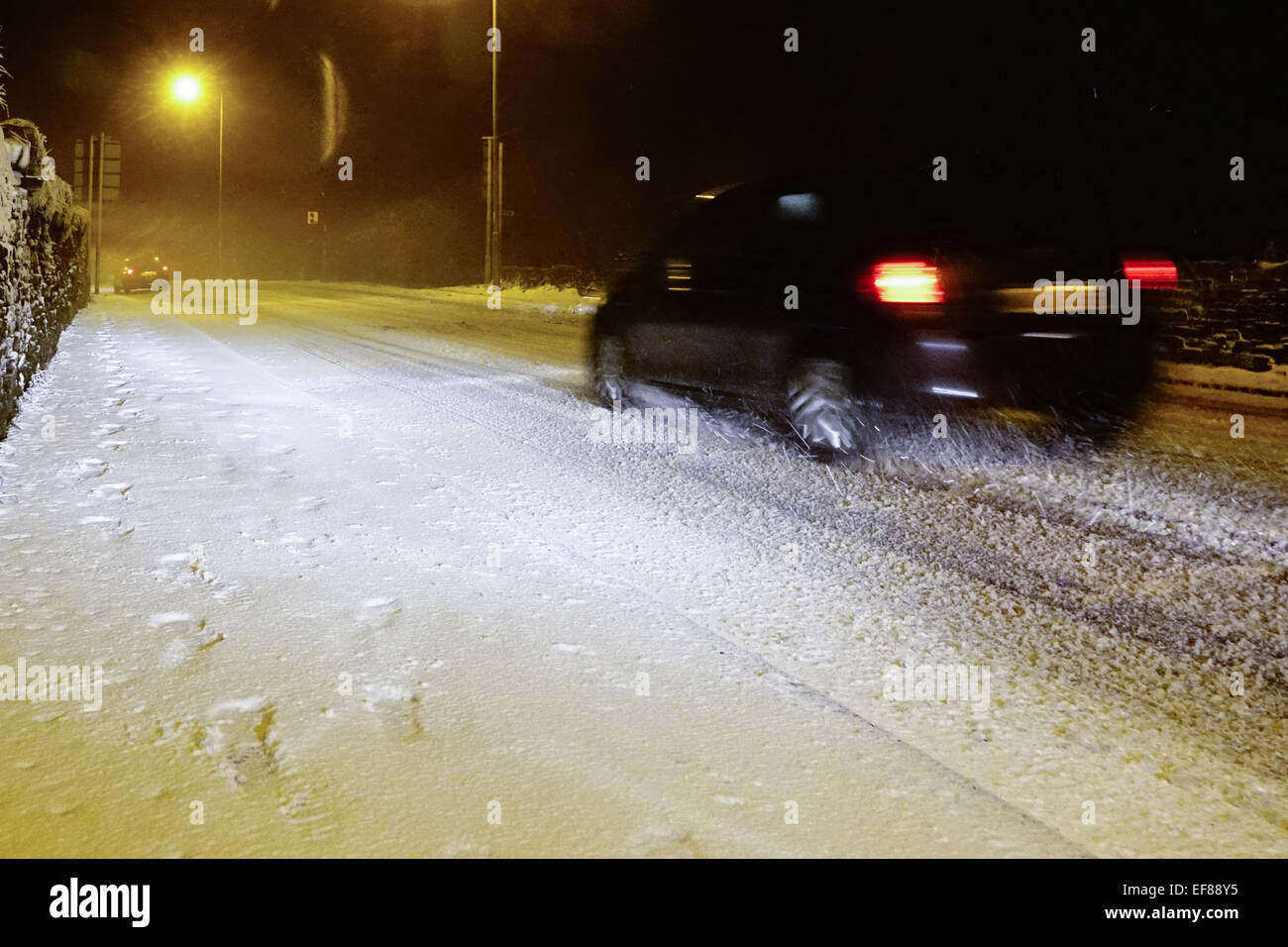 Car passing with motion blur on a snow covered road in Queensbury, West ...