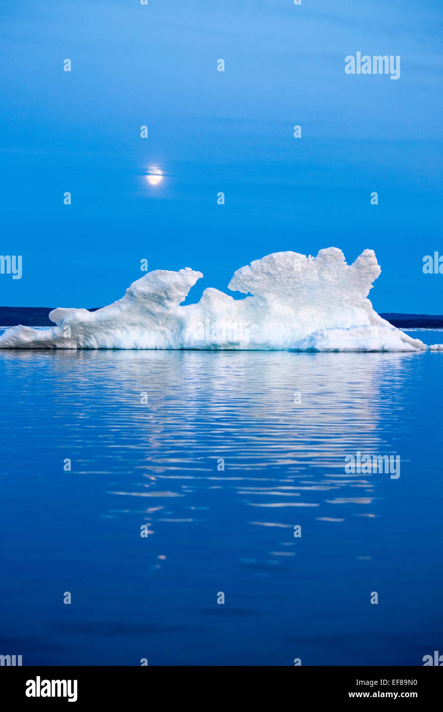 Canada, Nunavut Territory, Moon rises behind melting iceberg in Frozen ...