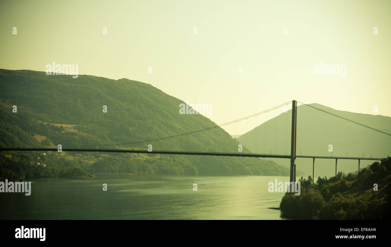 twilight above a surface of the sea and long suspension bridge in ...