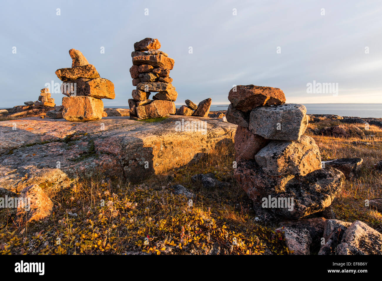 Canada, Nunavut, Territory, Setting sun lights stone cairns on Harbour ...