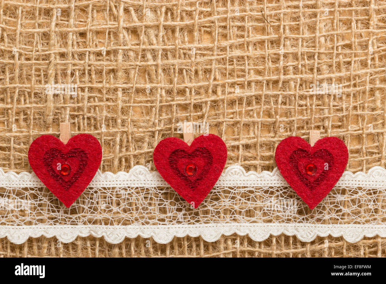 Valentines day or wedding concept. Red decorative hearts lace ribbon on ...