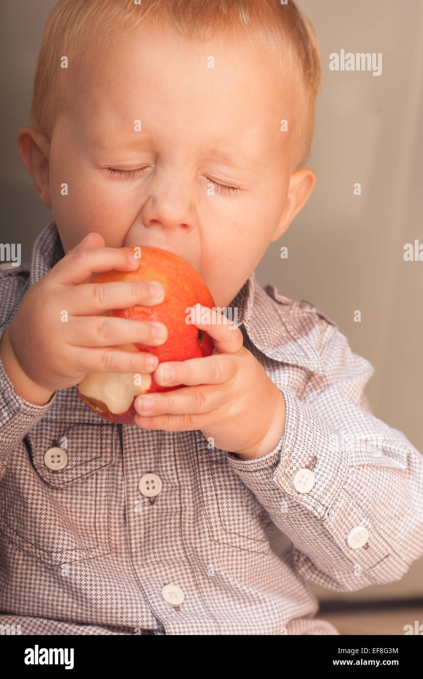 Happy childhood. Portrait of cute little boy child kid eating apple ...
