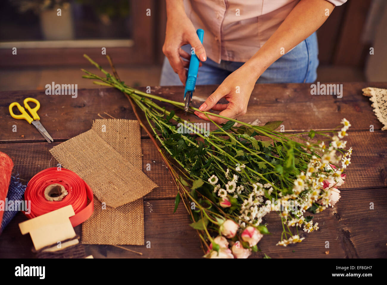 Female florist hands cutting floral stems at workplace Stock Photo - Alamy