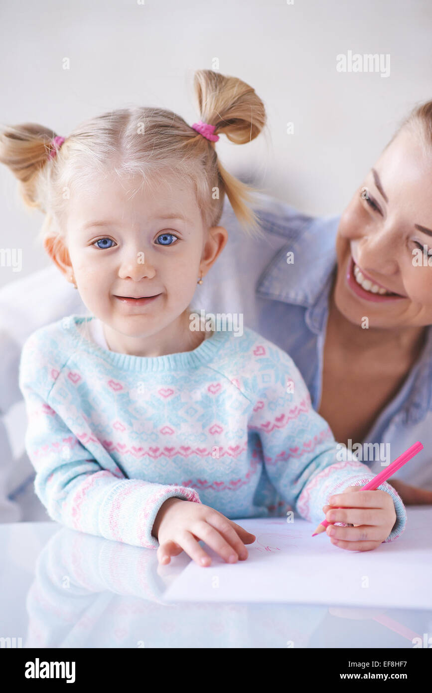Happy little girl with crayon and her mother near by Stock Photo - Alamy