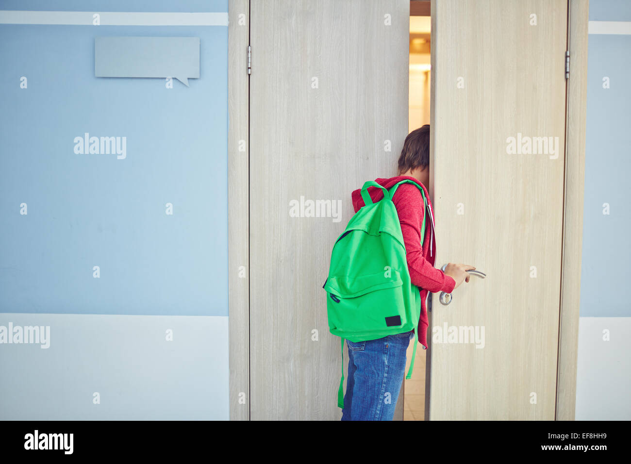Pre-teen schoolboy late for lesson looking into classroom Stock Photo ...