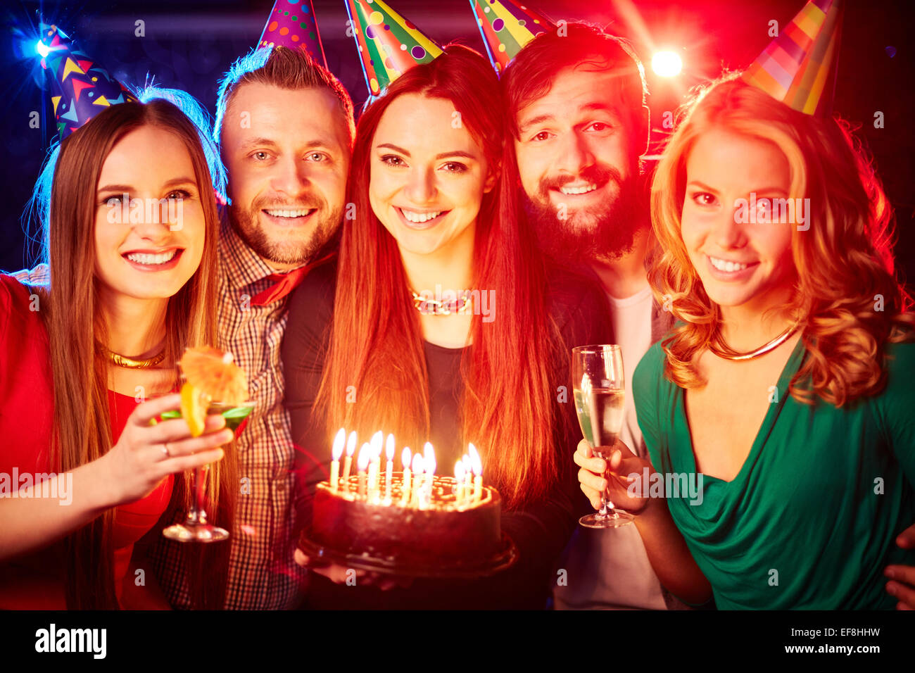 Group of happy friends in birthday caps looking at camera Stock Photo ...