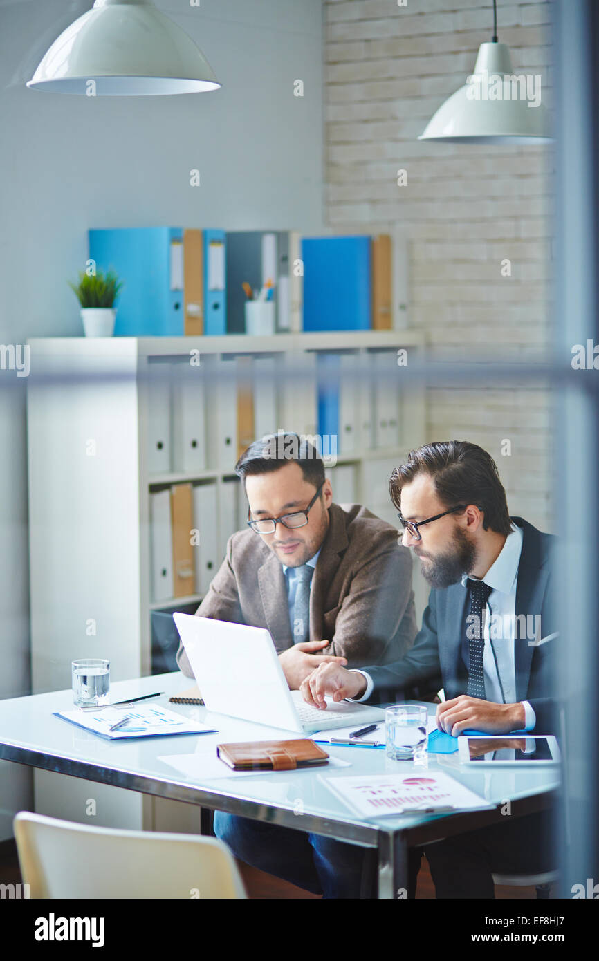 Young business partners networking in office Stock Photo - Alamy