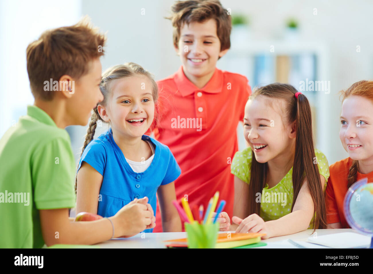 Friendly boys and girls talking and laughing at break in school Stock ...