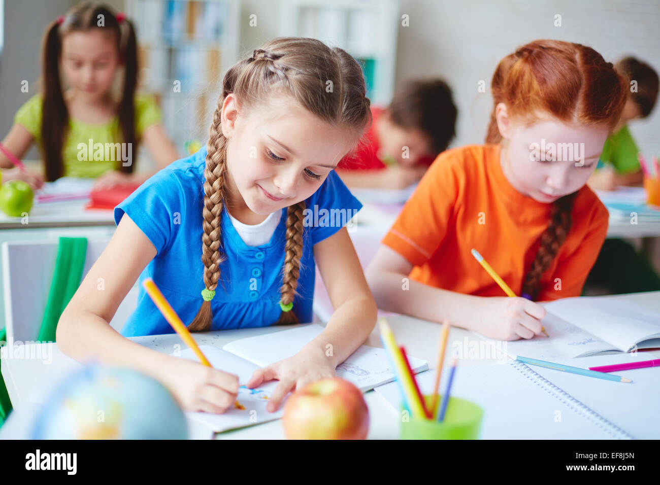 Diligent girls drawing with crayons at lesson Stock Photo - Alamy
