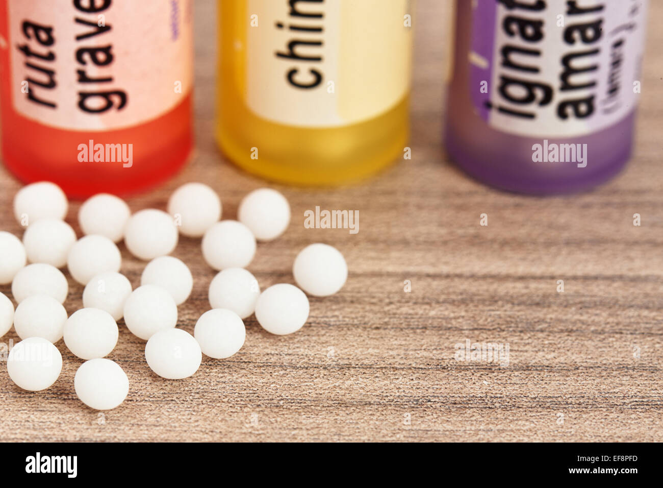 Homeopathic globules scattered around with their colored containers in ...