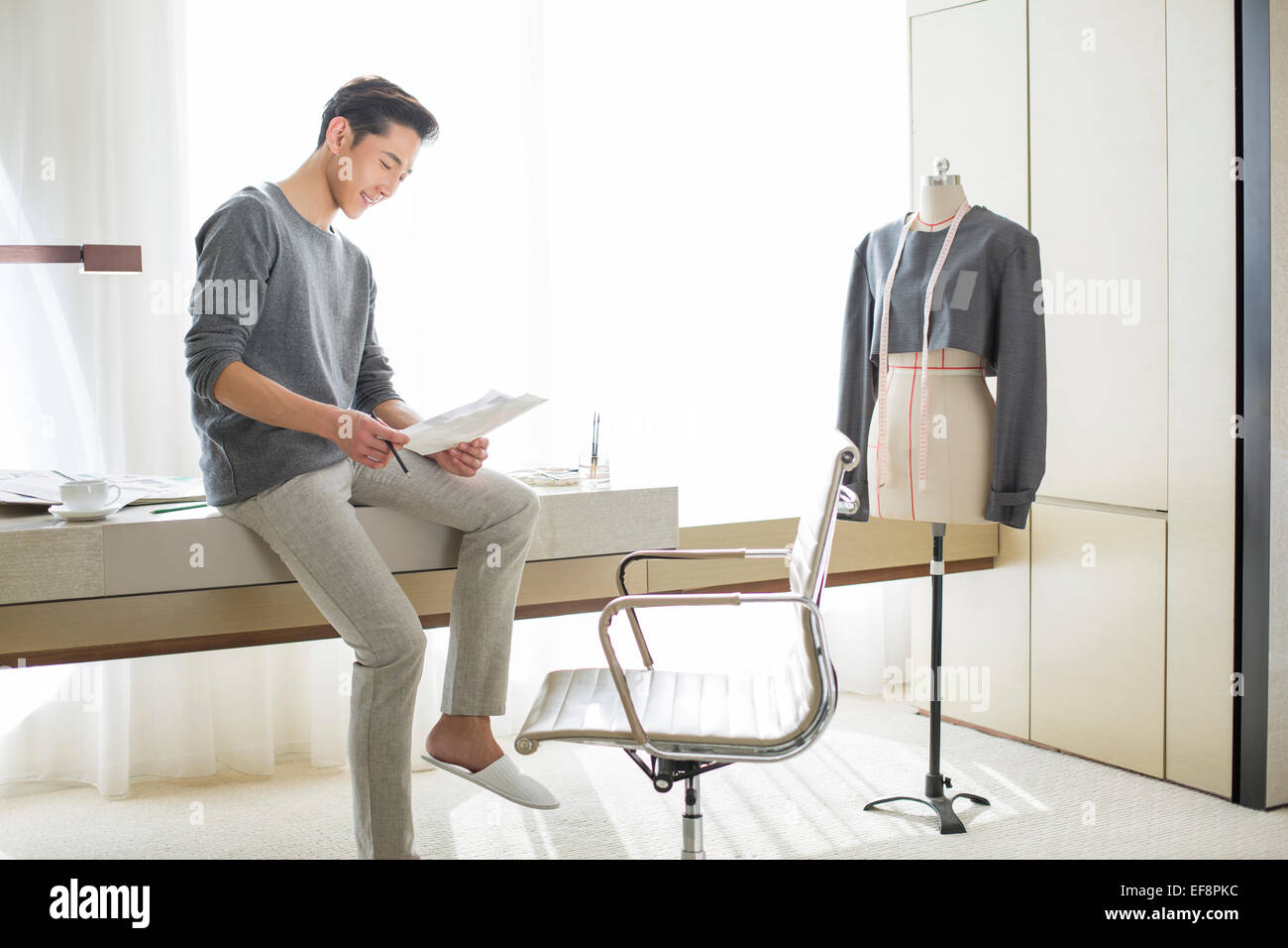 Fashion designer looking at sketch Stock Photo - Alamy