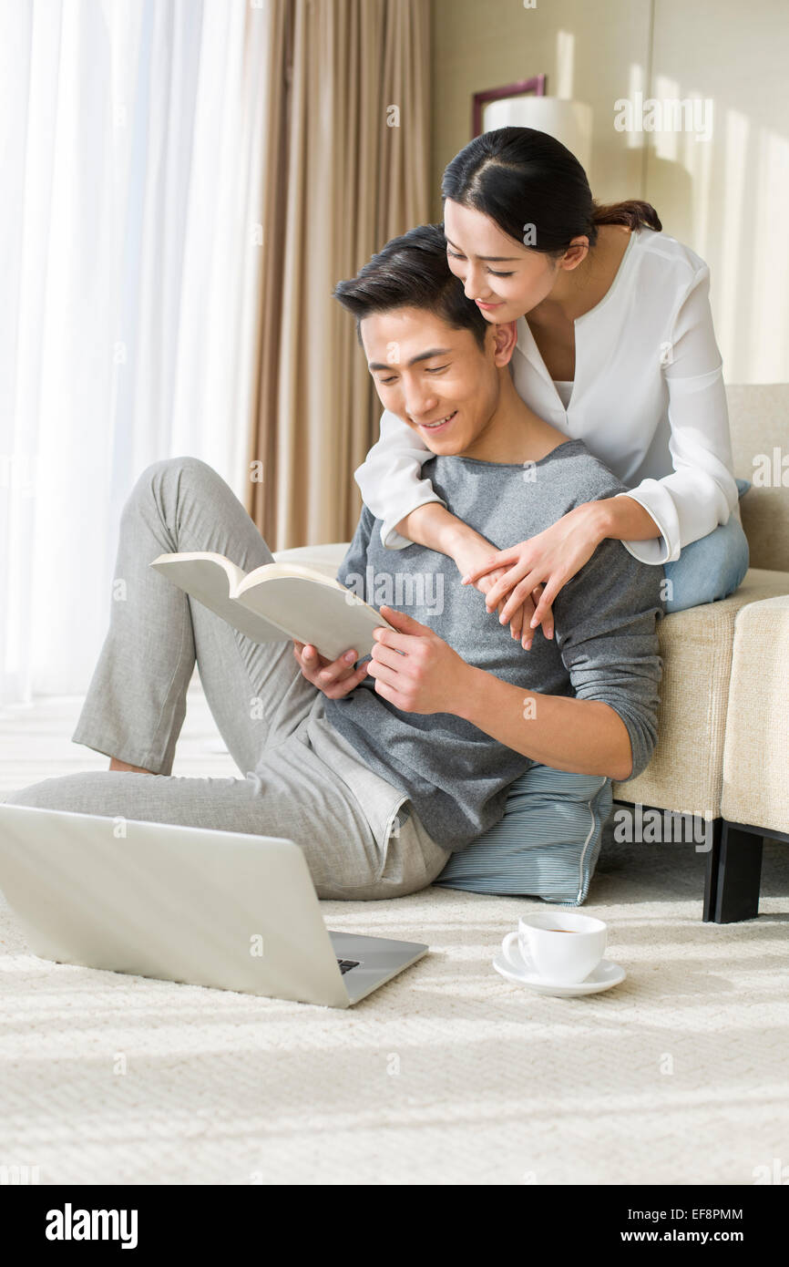 Young couple reading book at home Stock Photo - Alamy