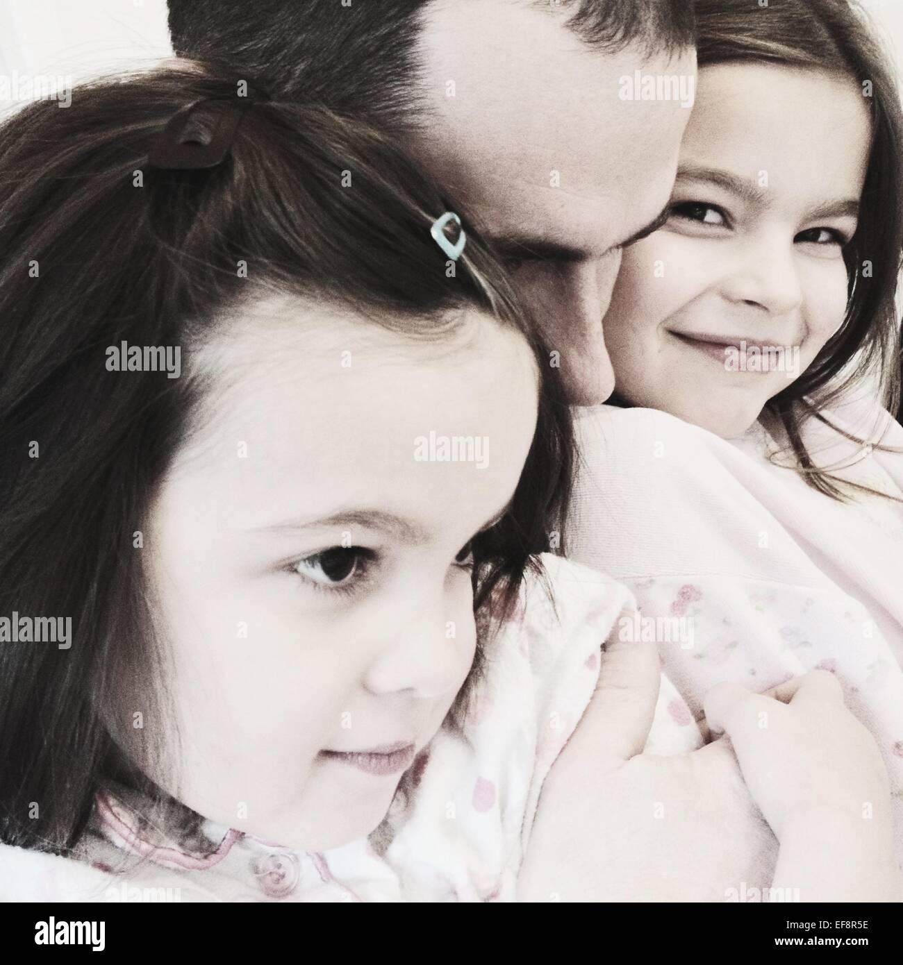 Portrait of father and two daughters embracing Stock Photo - Alamy