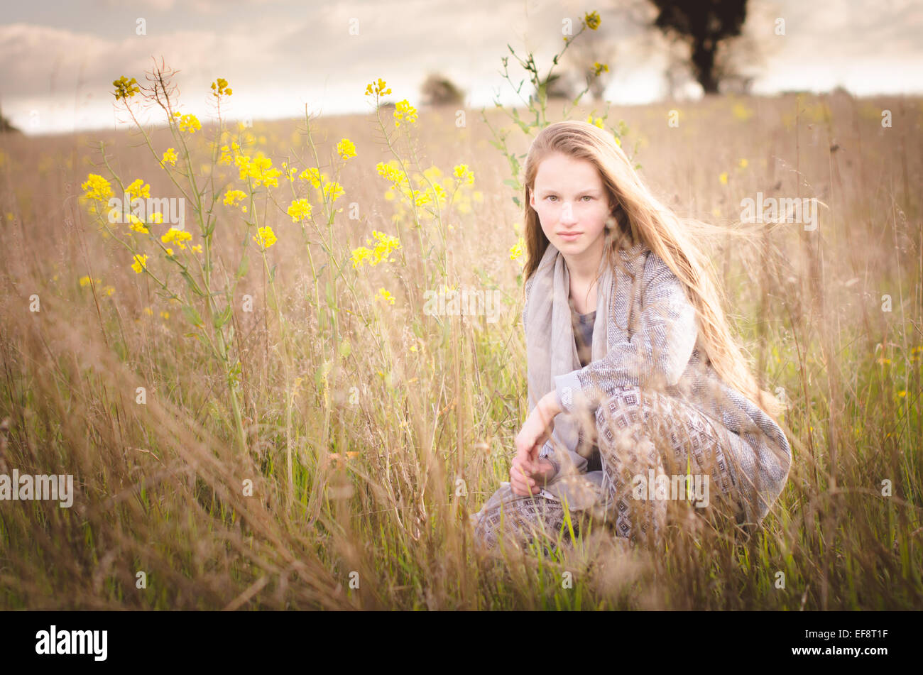Portrait of teenage girl sitting in a field Stock Photo - Alamy