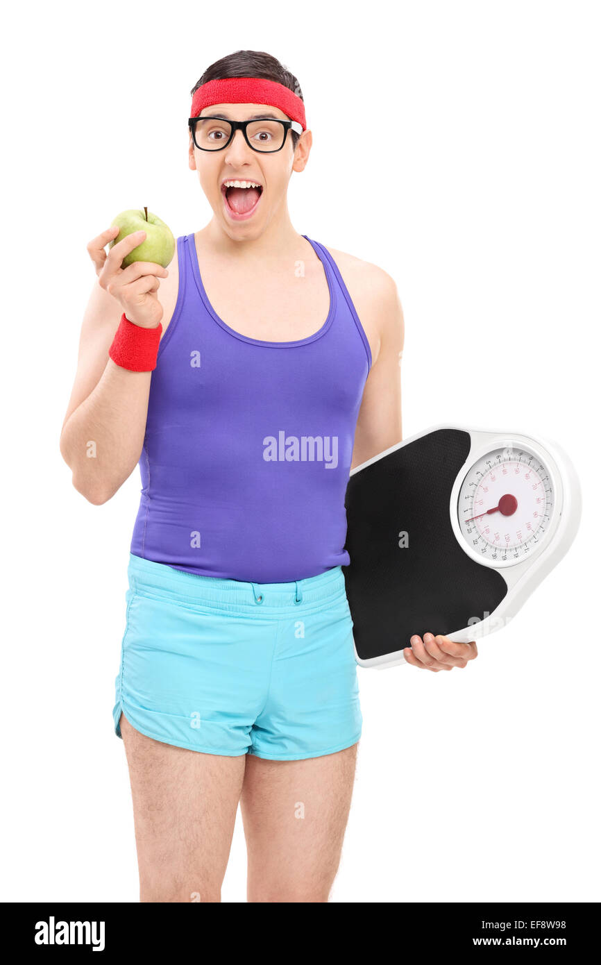 Nerdy guy eating apple and holding a weight scale isolated on white ...