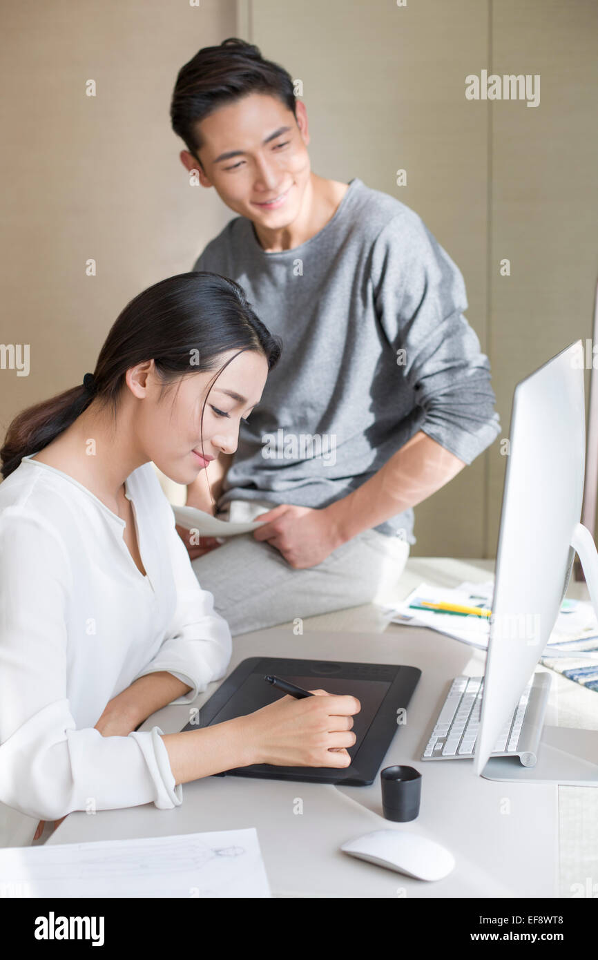 Young couple designing clothing together Stock Photo - Alamy