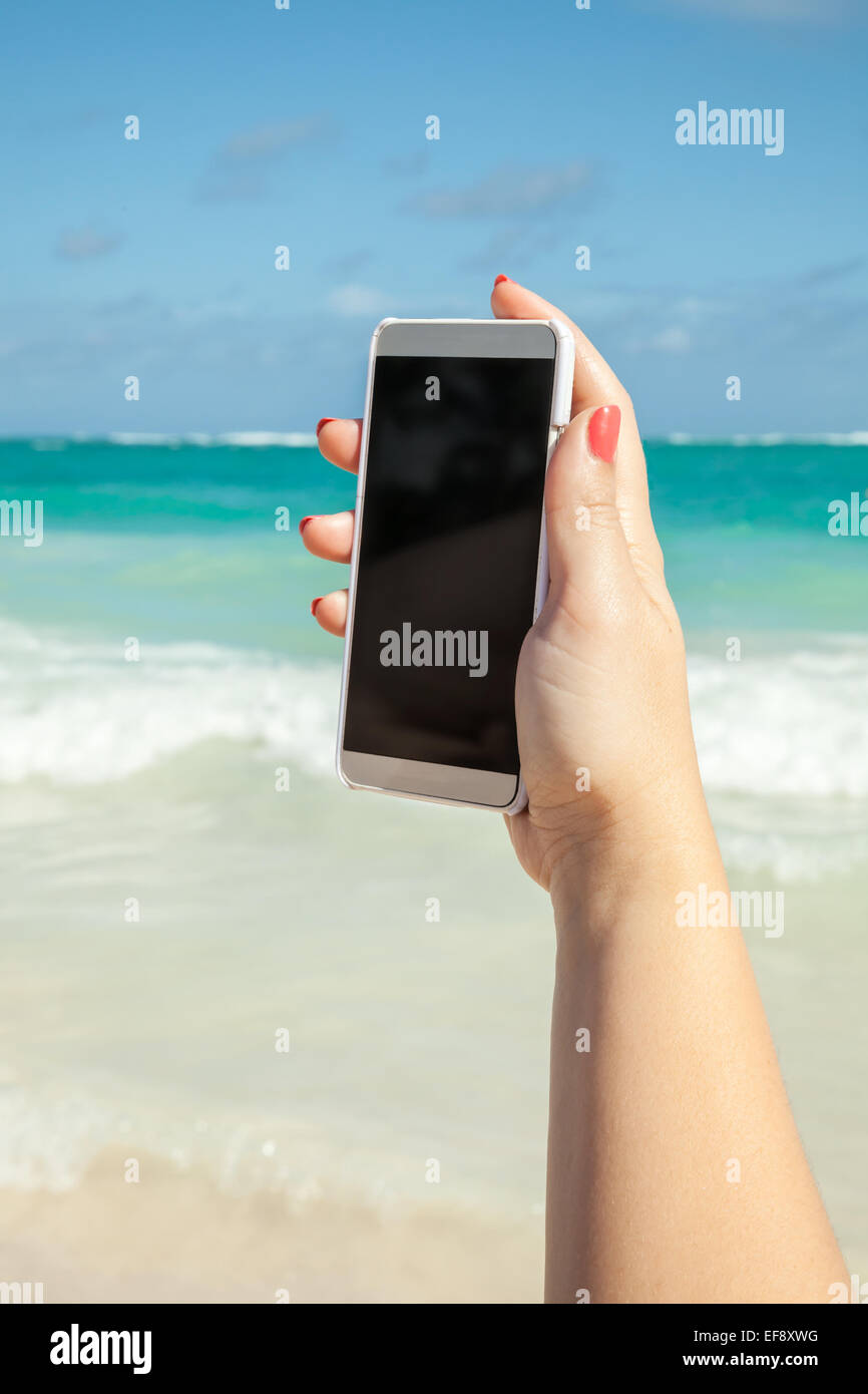 Woman with a cellphone in the beach hi-res stock photography and images ...