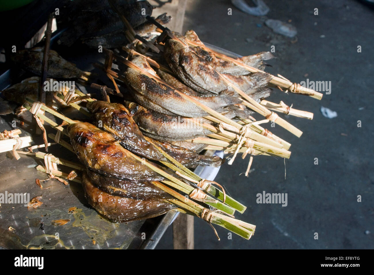 Grilled fish is available as street food on a city street in Kampong ...