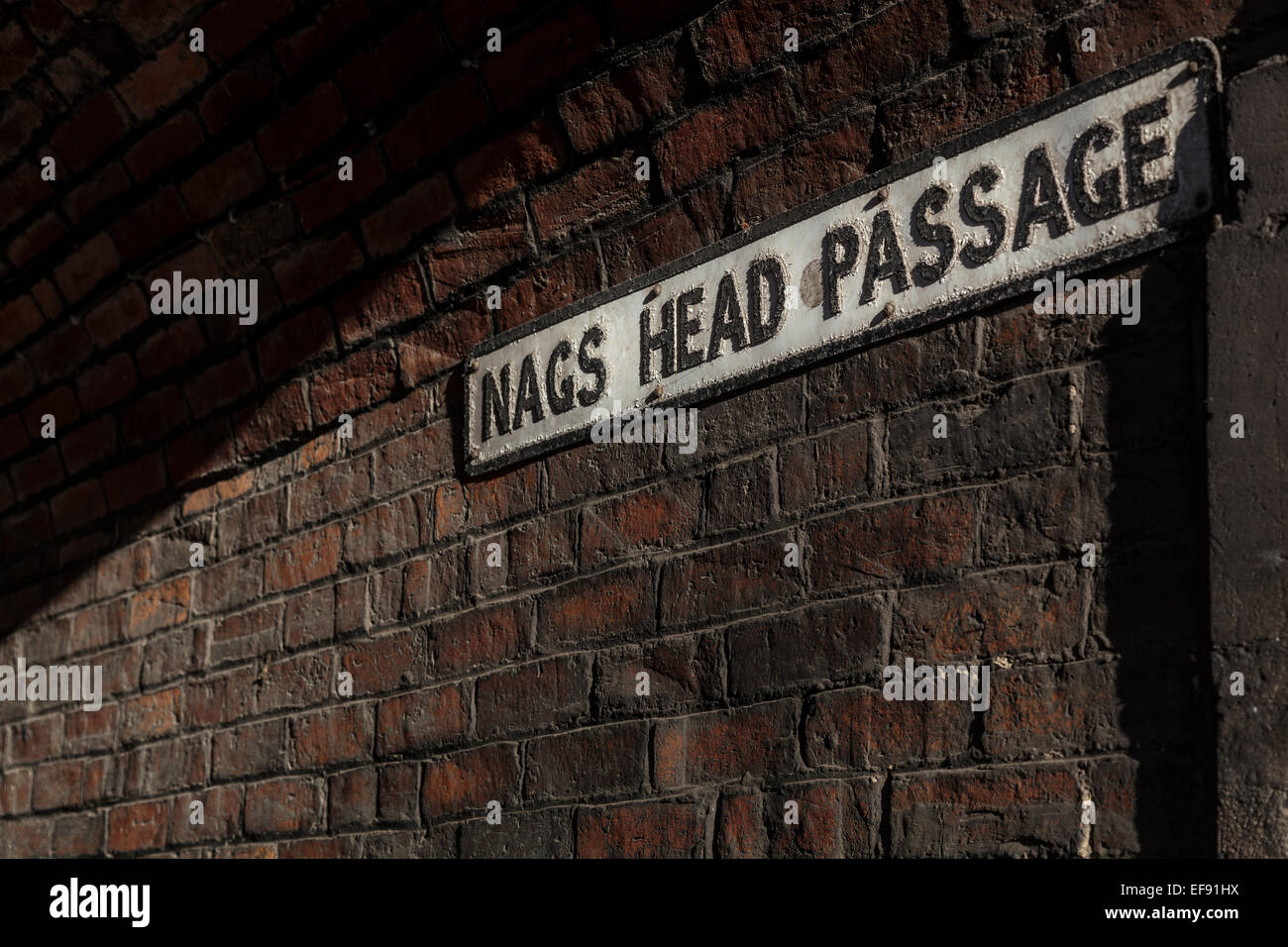 Old metal street sign 'Nags head passage' on an old brick wall ...