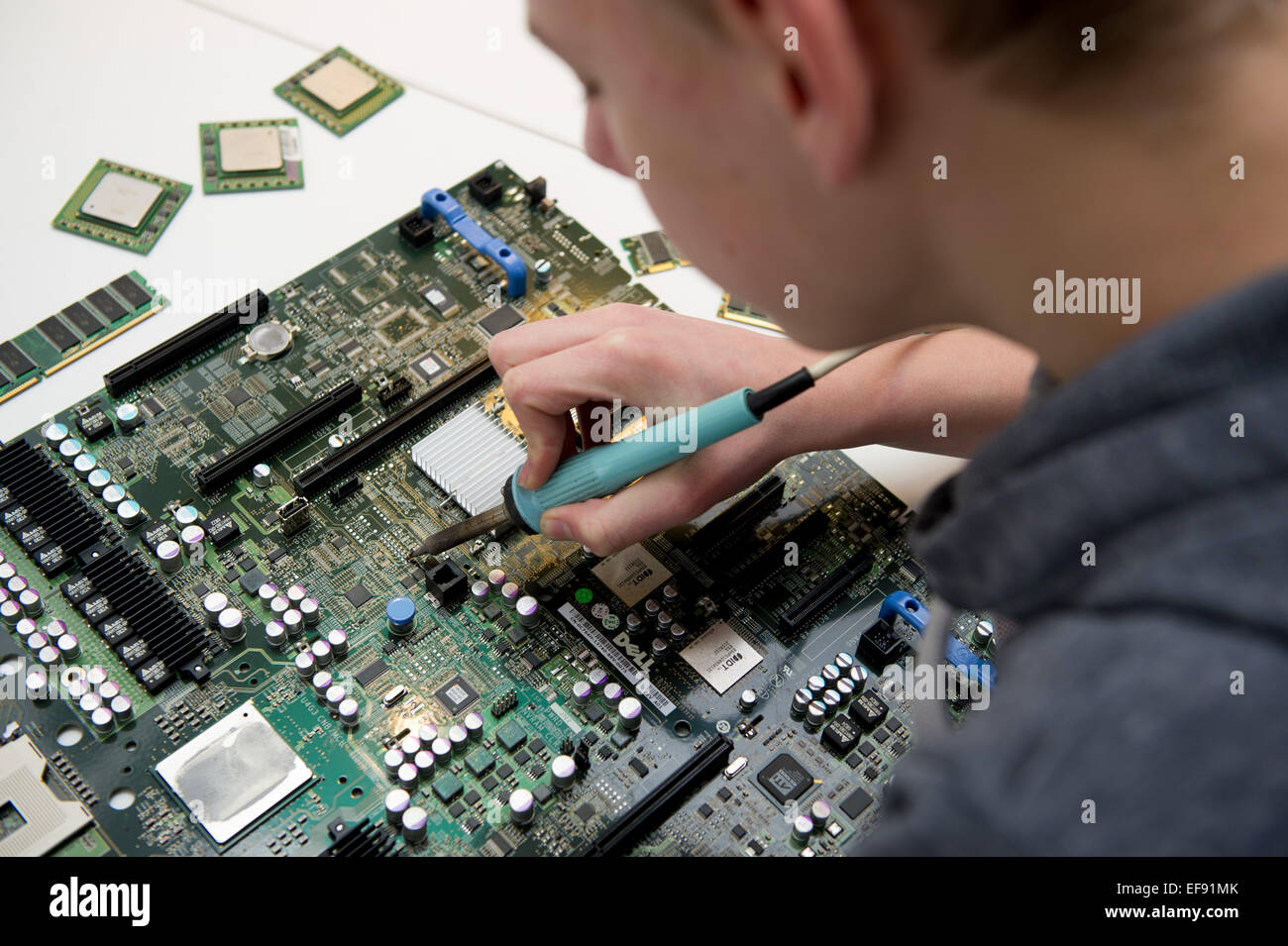 A boy working on the innards of a computer. Photo: Jan Haas Stock Photo ...