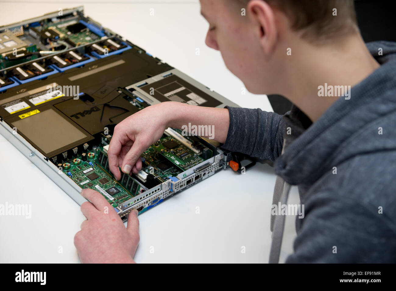 A boy working on the innards of a computer. Photo: Jan Haas Stock Photo ...