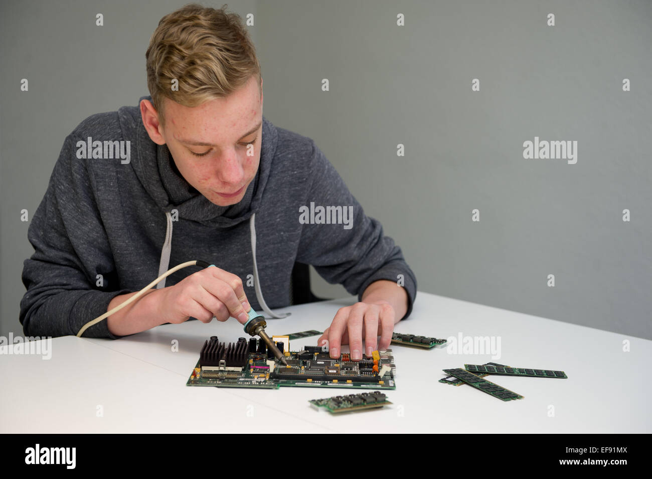A boy working on the innards of a computer. Photo: Jan Haas Stock Photo ...