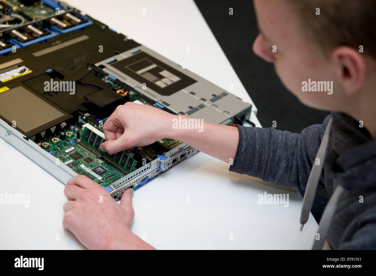 A boy working on the innards of a computer. Photo: Jan Haas Stock Photo ...