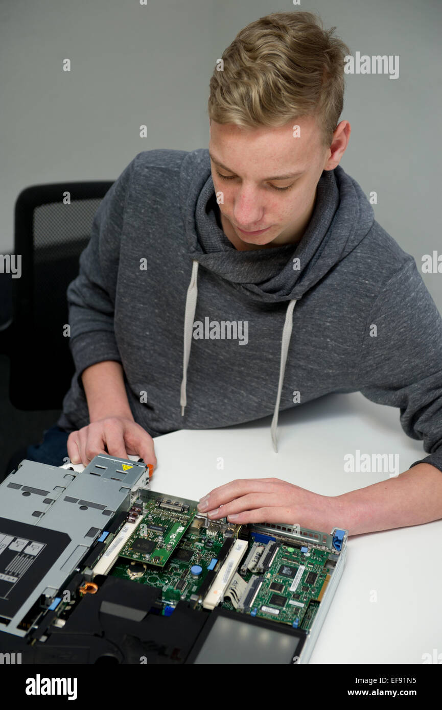 A boy working on the innards of a computer. Photo: Jan Haas Stock Photo ...