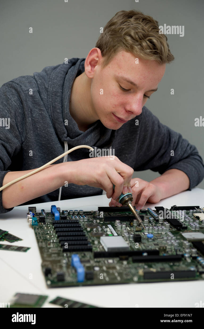 A boy working on the innards of a computer. Photo: Jan Haas Stock Photo ...