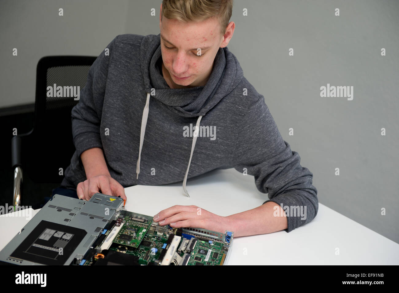 A boy working on the innards of a computer. Photo: Jan Haas Stock Photo ...