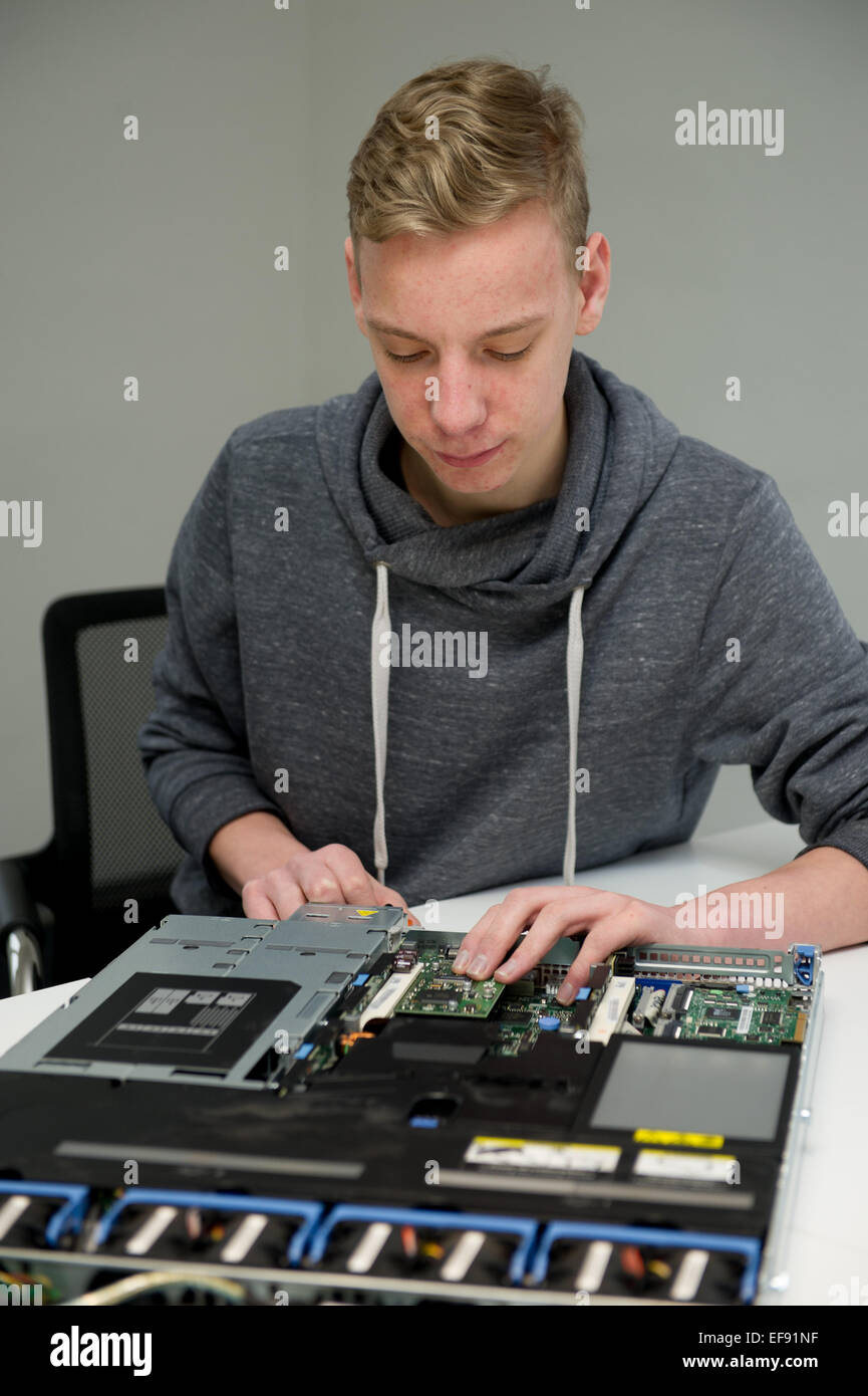 A boy working on the innards of a computer. Photo: Jan Haas Stock Photo ...