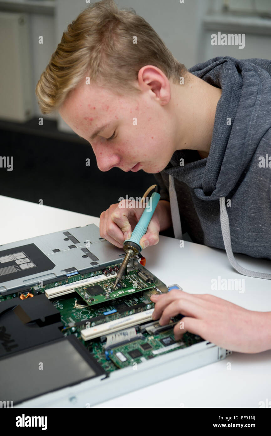 A boy working on the innards of a computer. Photo: Jan Haas Stock Photo ...