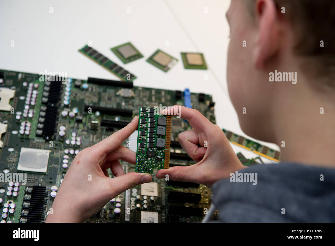 A boy working on the innards of a computer. Photo: Jan Haas Stock Photo ...