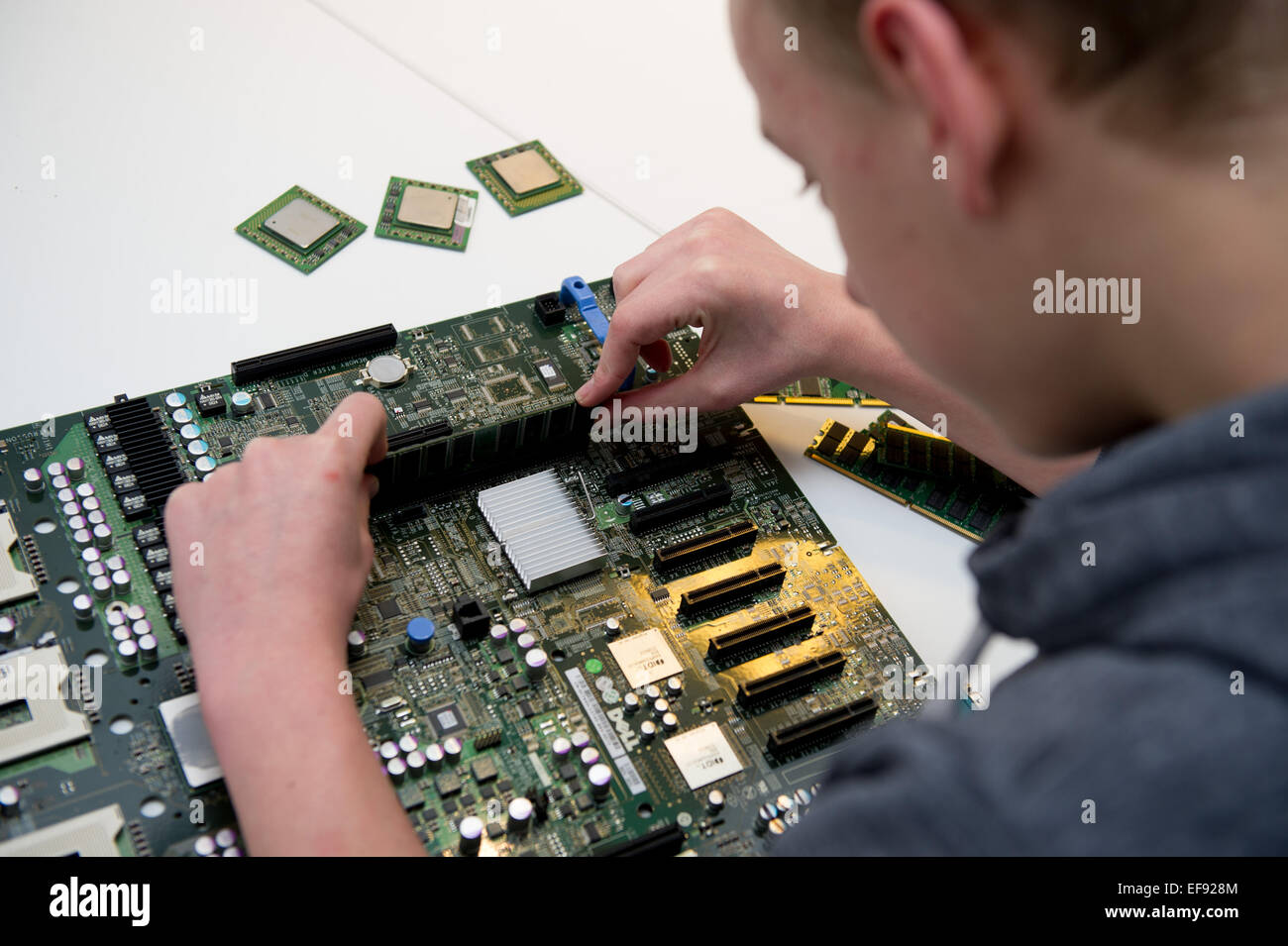 A boy working on the innards of a computer. Photo: Jan Haas Stock Photo ...