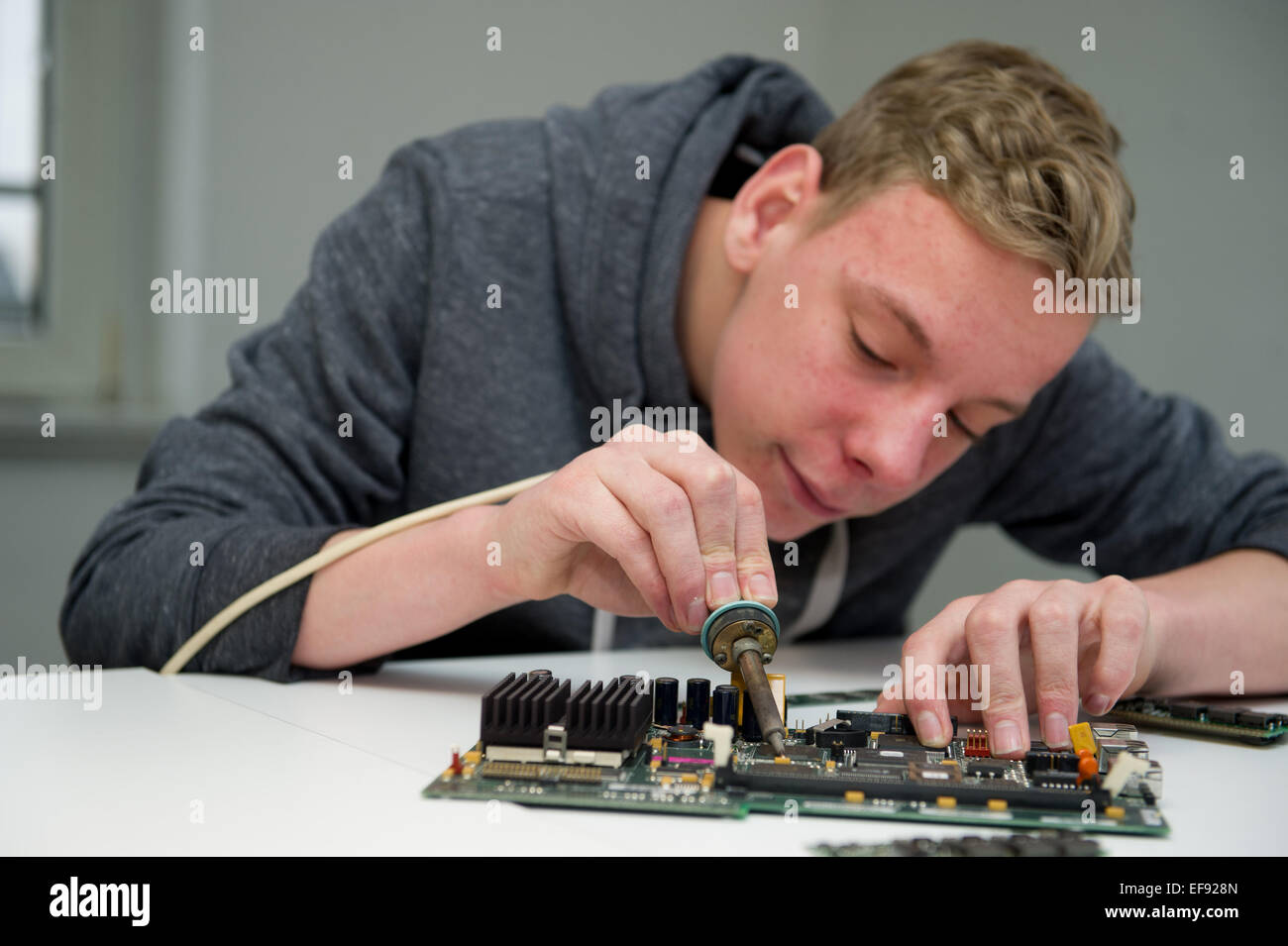 A boy working on the innards of a computer. Photo: Jan Haas Stock Photo ...