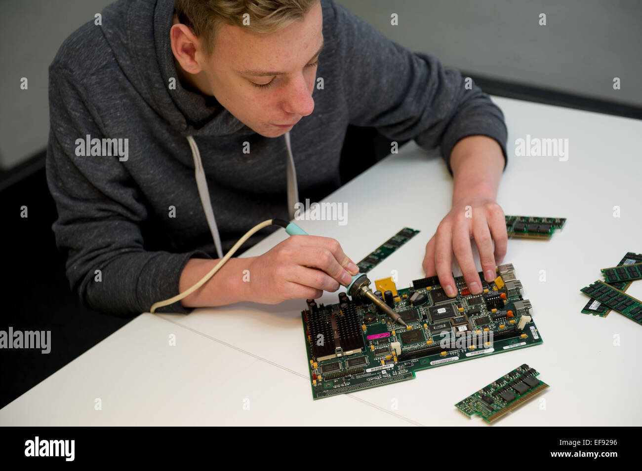 A boy working on the innards of a computer. Photo: Jan Haas Stock Photo ...