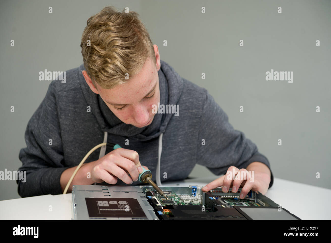 A boy working on the innards of a computer. Photo: Jan Haas Stock Photo ...