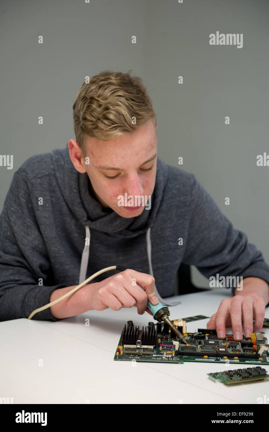 A boy working on the innards of a computer. Photo: Jan Haas Stock Photo ...