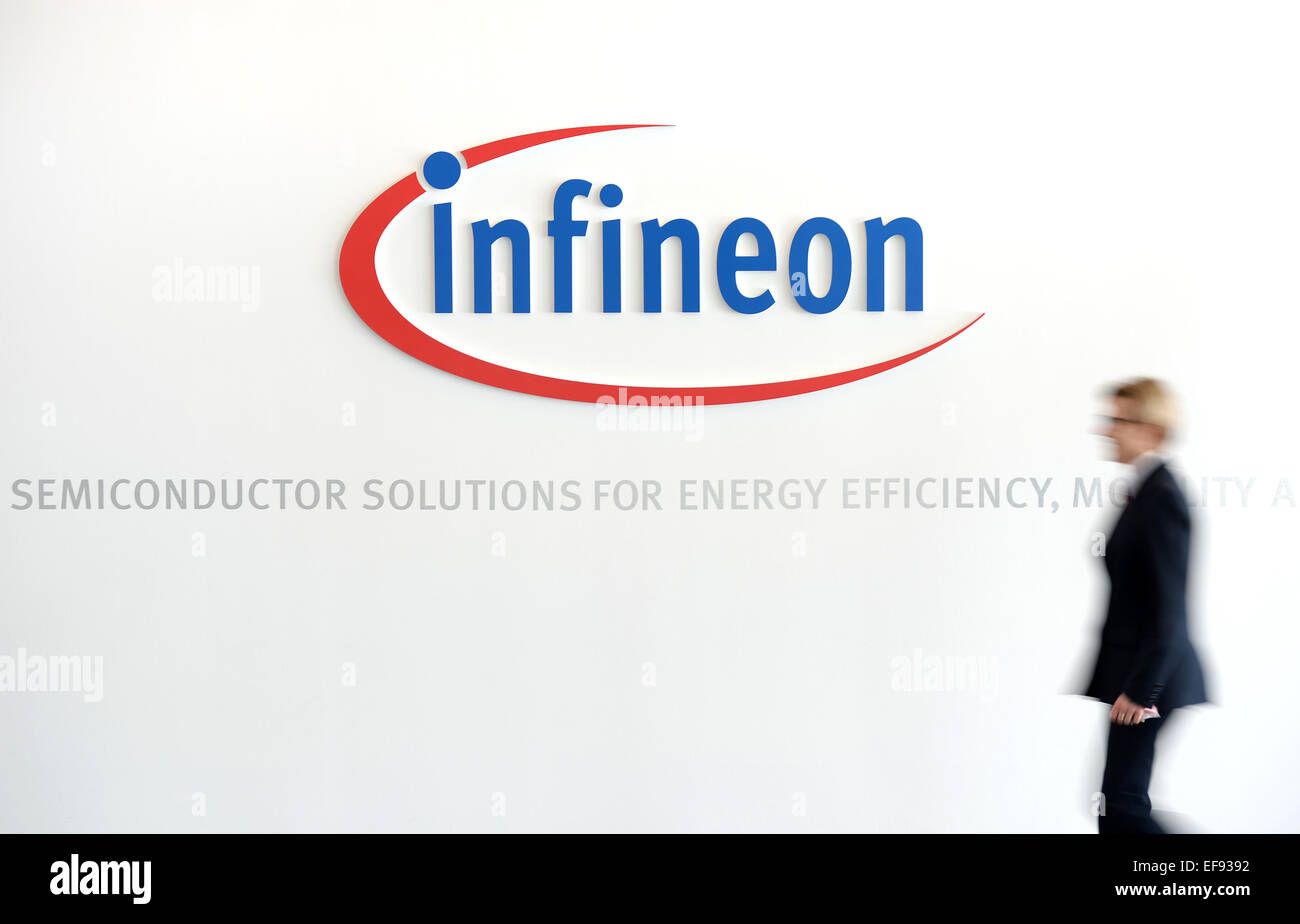 A woman walks past the logo of semiconductor manufacturer Infineon at ...